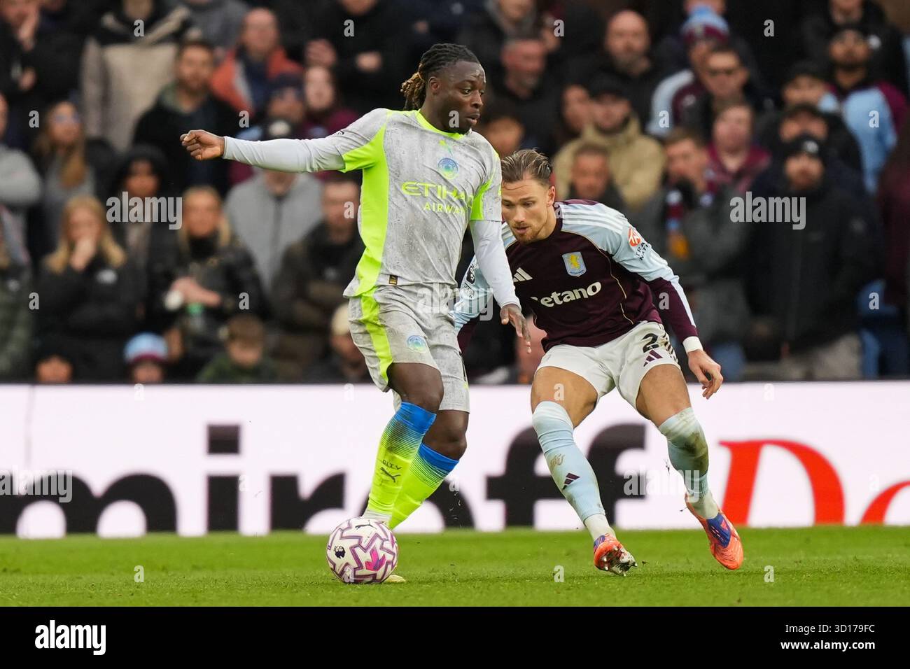 Jeremy Doku of Manchester City under pressure from Matty Cash of Aston ...