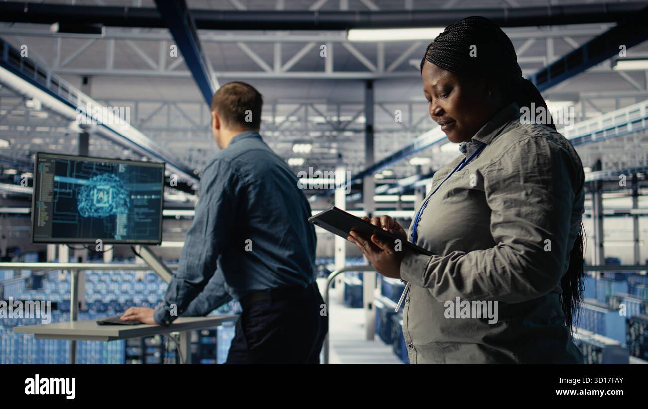 Data center employee monitoring infrastructure processes, reviewing ...