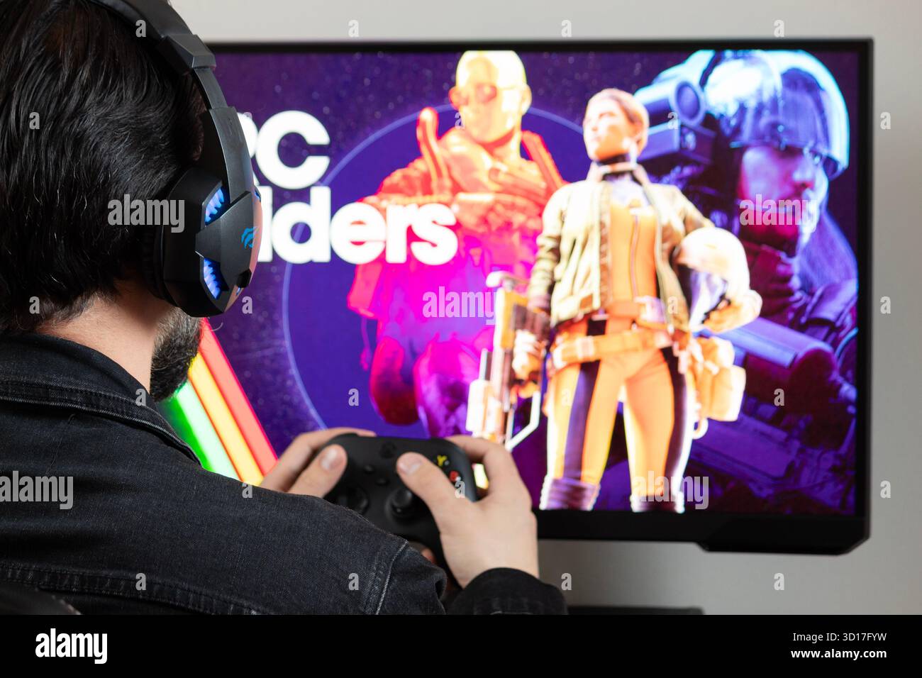Close up to a gamer at the left side of the picture holding a xbox ...