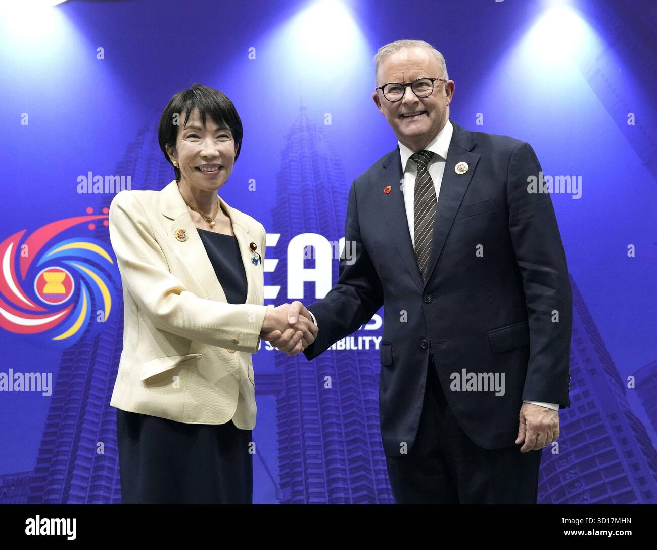 Japanese Prime Minister Sanae Takaichi (L) shakes hands with Australian ...