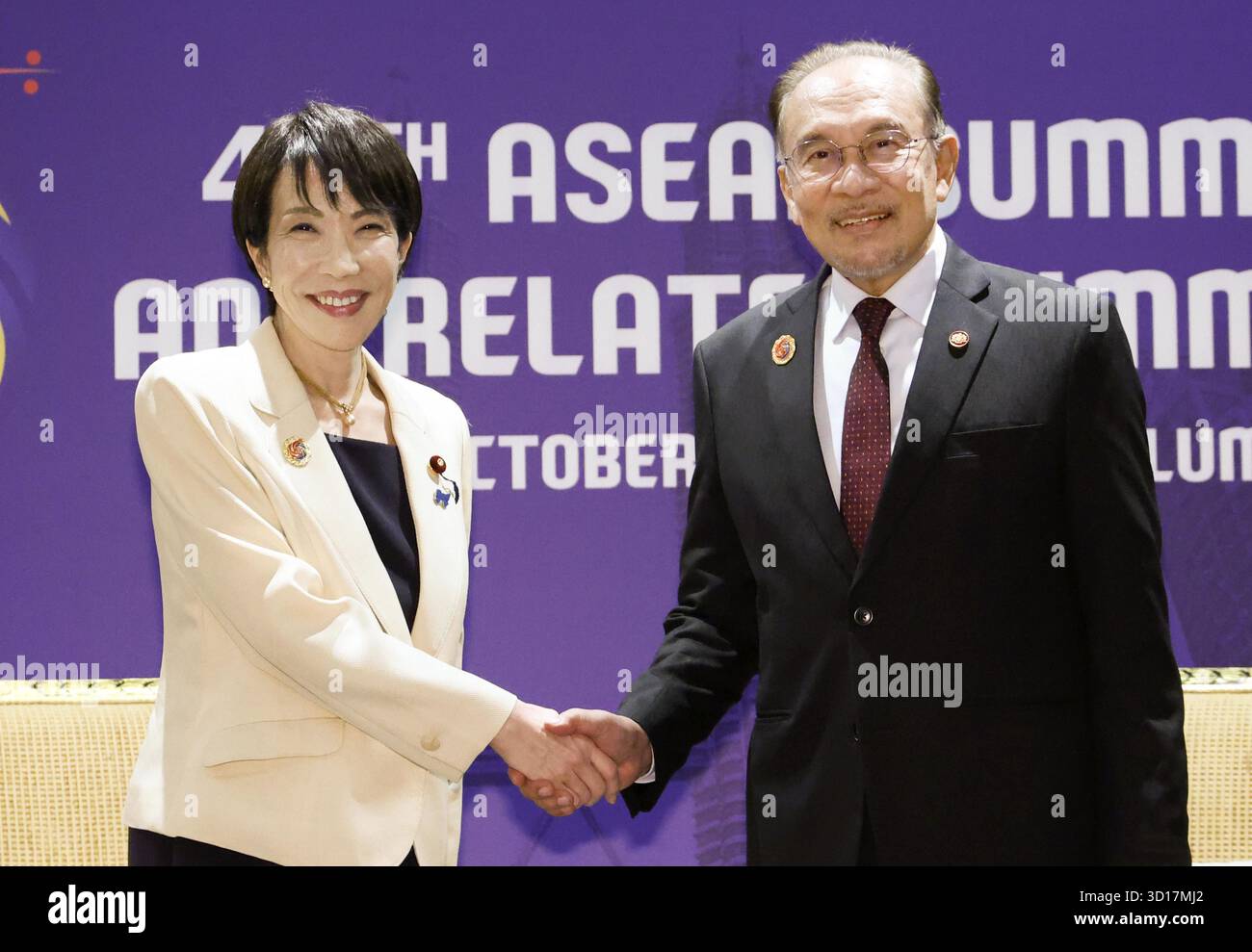 Japanese Prime Minister Sanae Takaichi (L) shakes hands with Malaysian ...