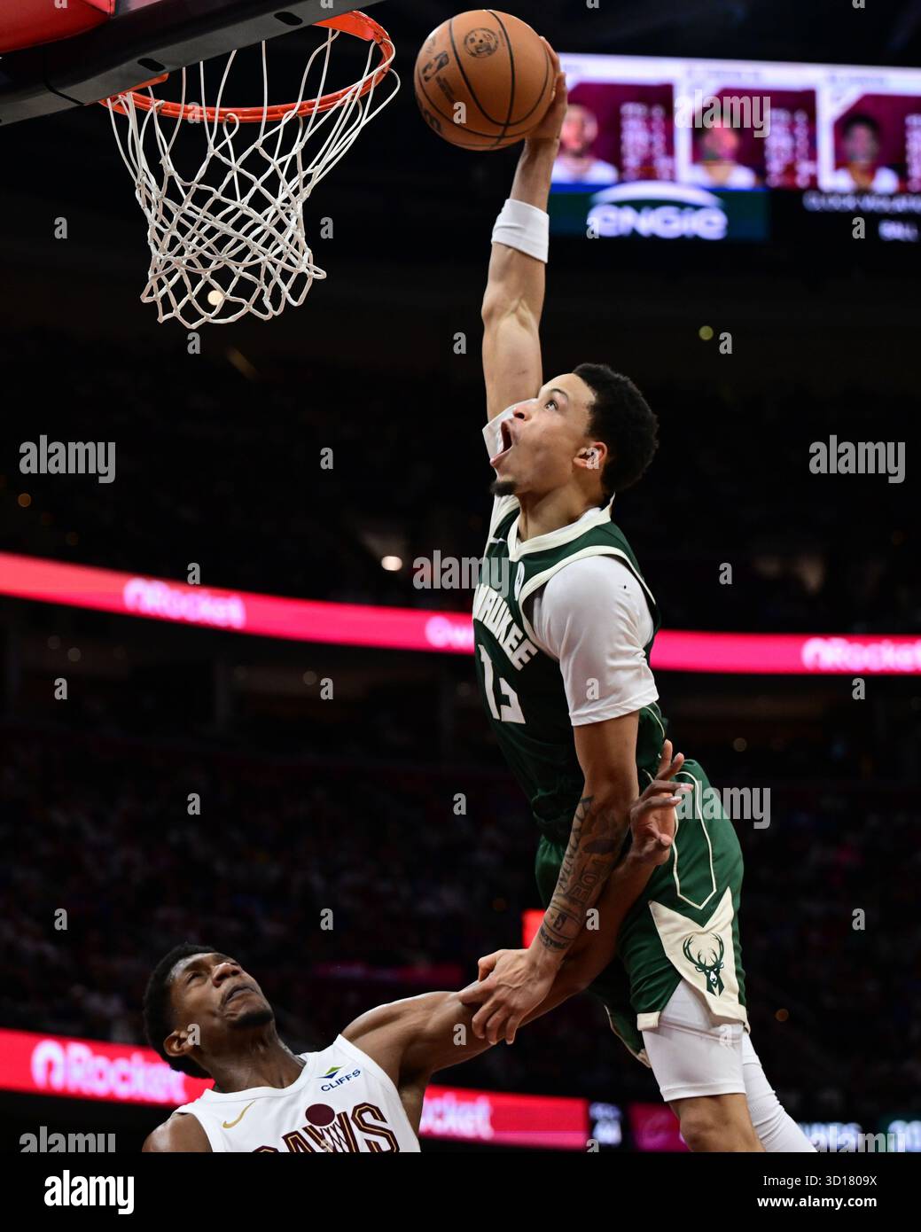 Milwaukee Bucks guard Ryan Rollins, top, dunks over Cleveland Cavaliers ...
