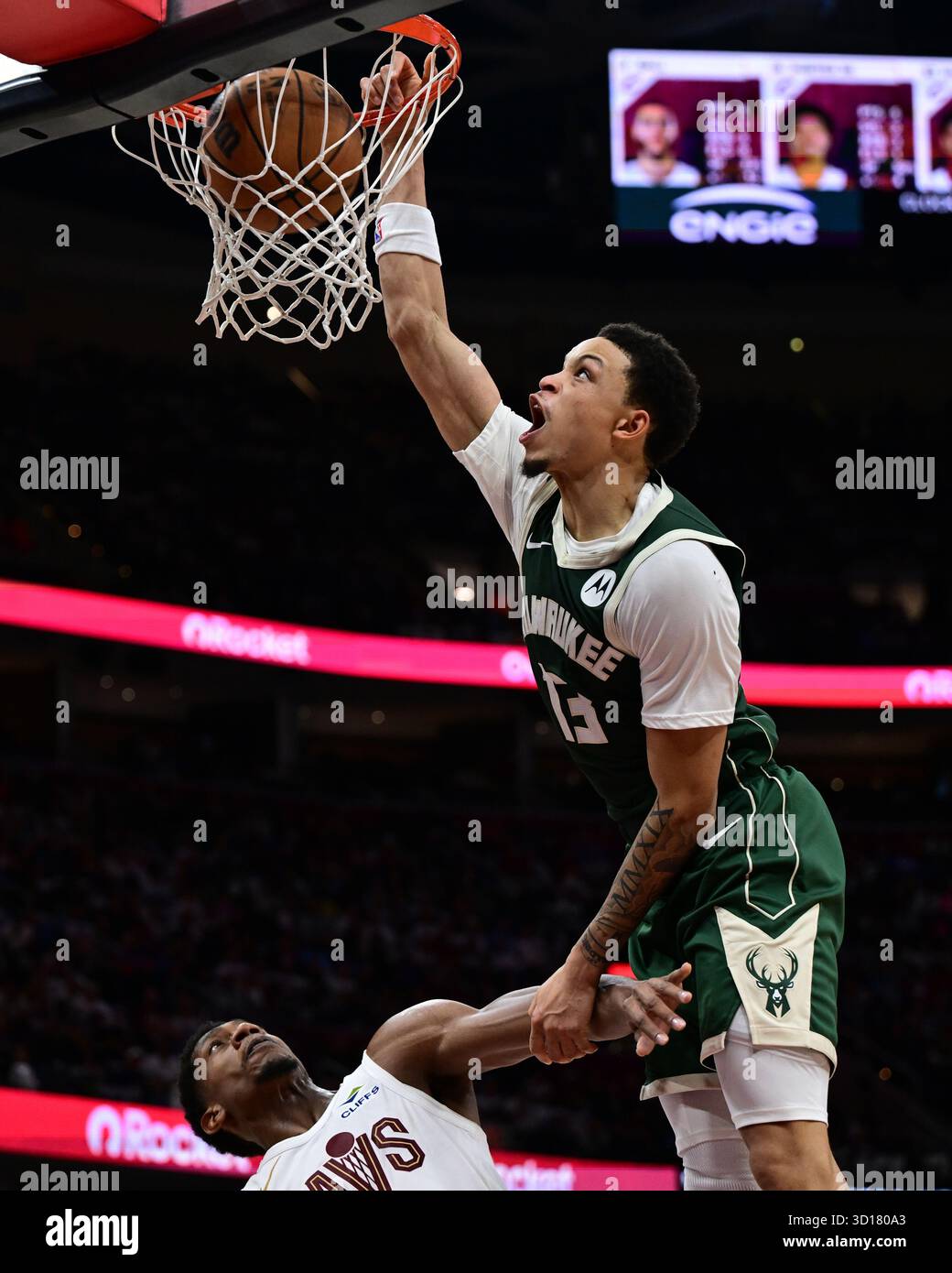 Milwaukee Bucks guard Ryan Rollins, top, dunks over Cleveland Cavaliers ...