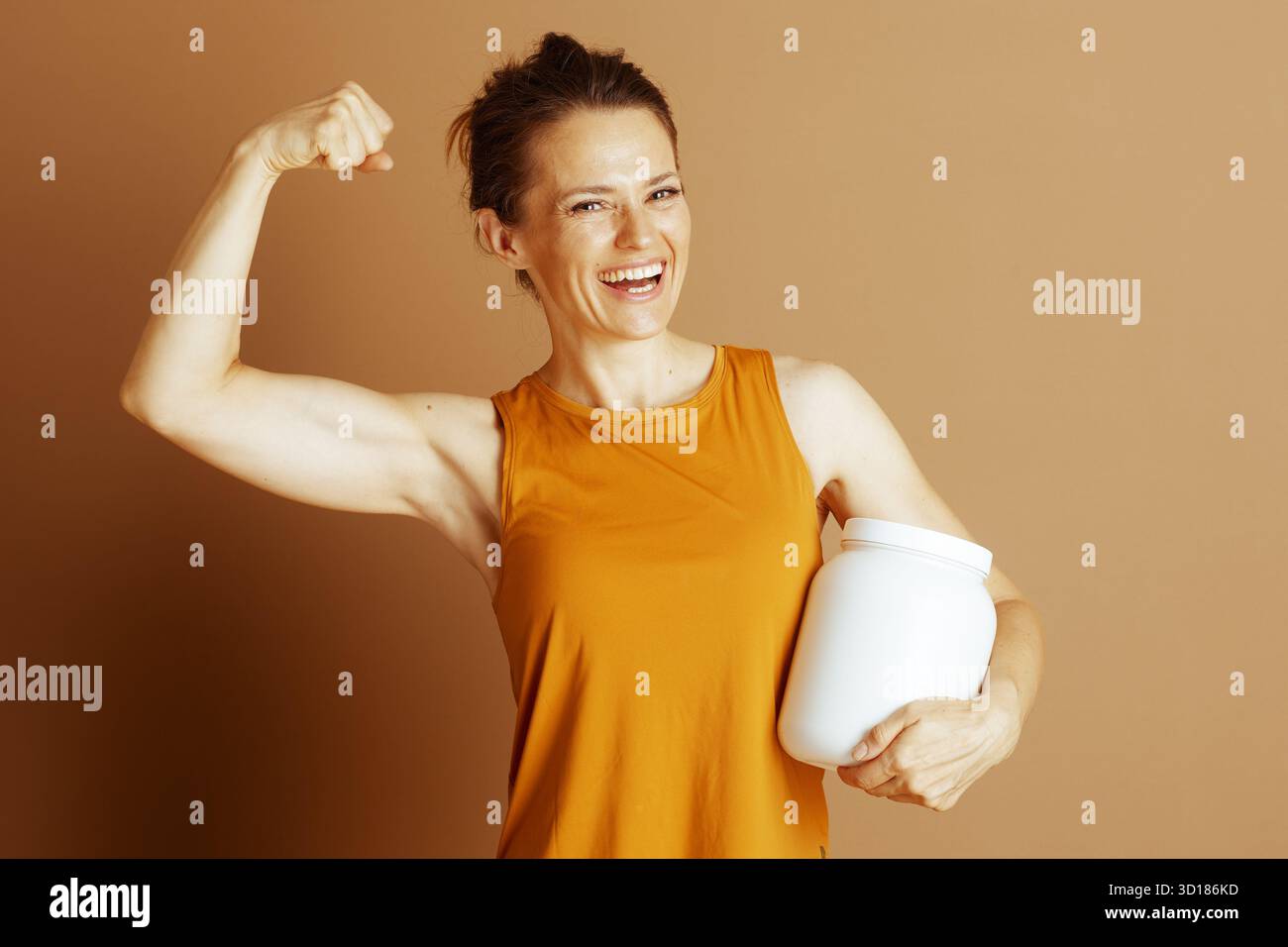 Woman flexes bicep smiling hi-res stock photography and images - Alamy