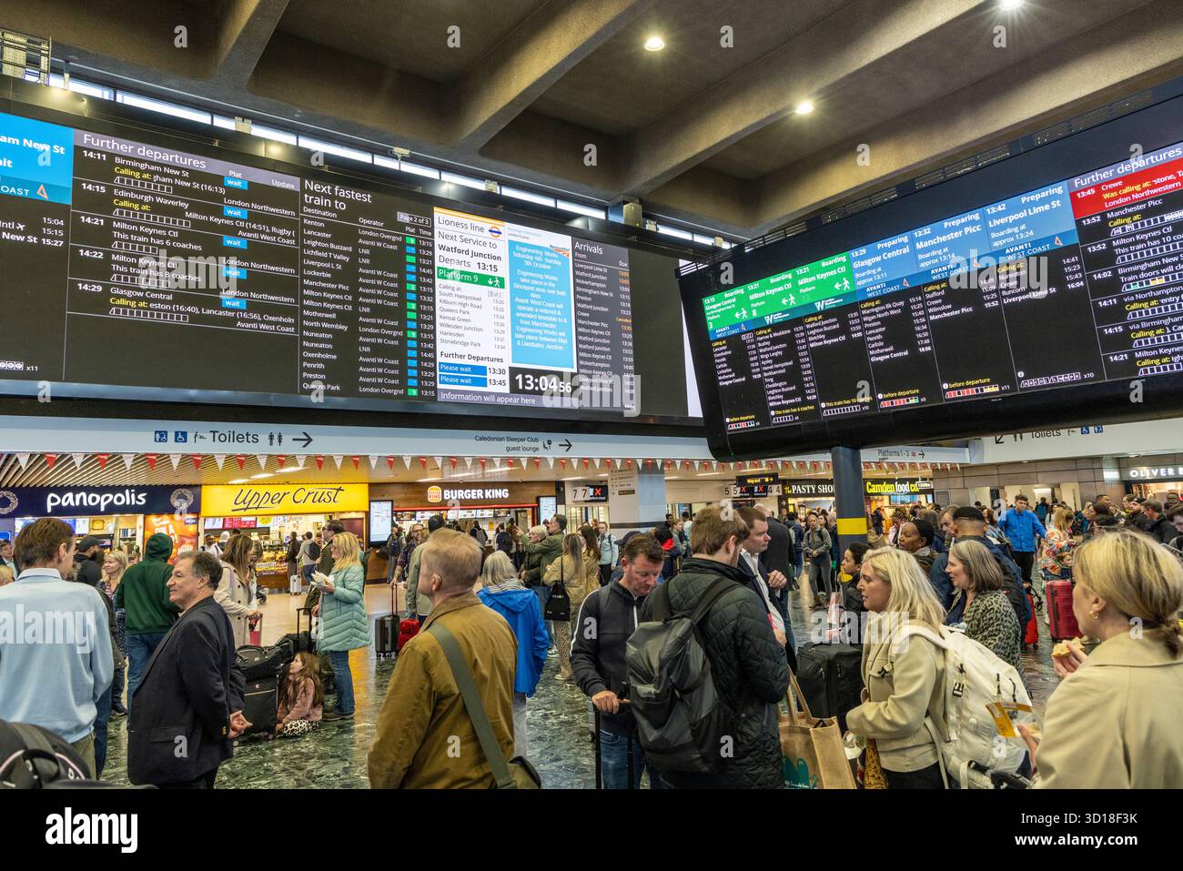 London Euston rail railway station, concourse passengers wait for their ...