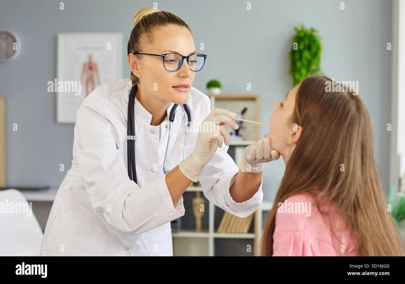 Pediatrician taking throat swab from child patient during exam in ...