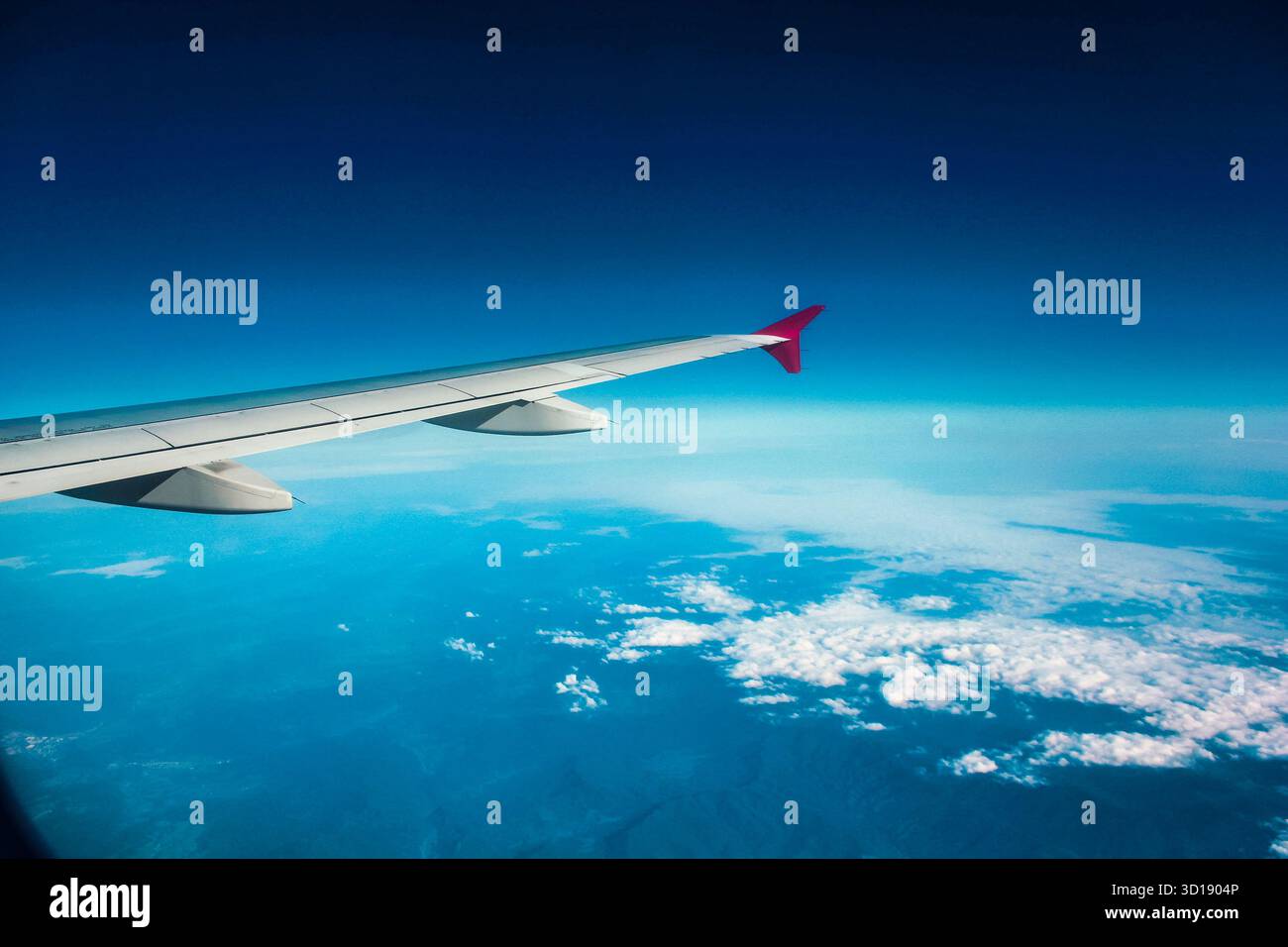 The image shows an airplane wing as seen from the window of the cabin ...