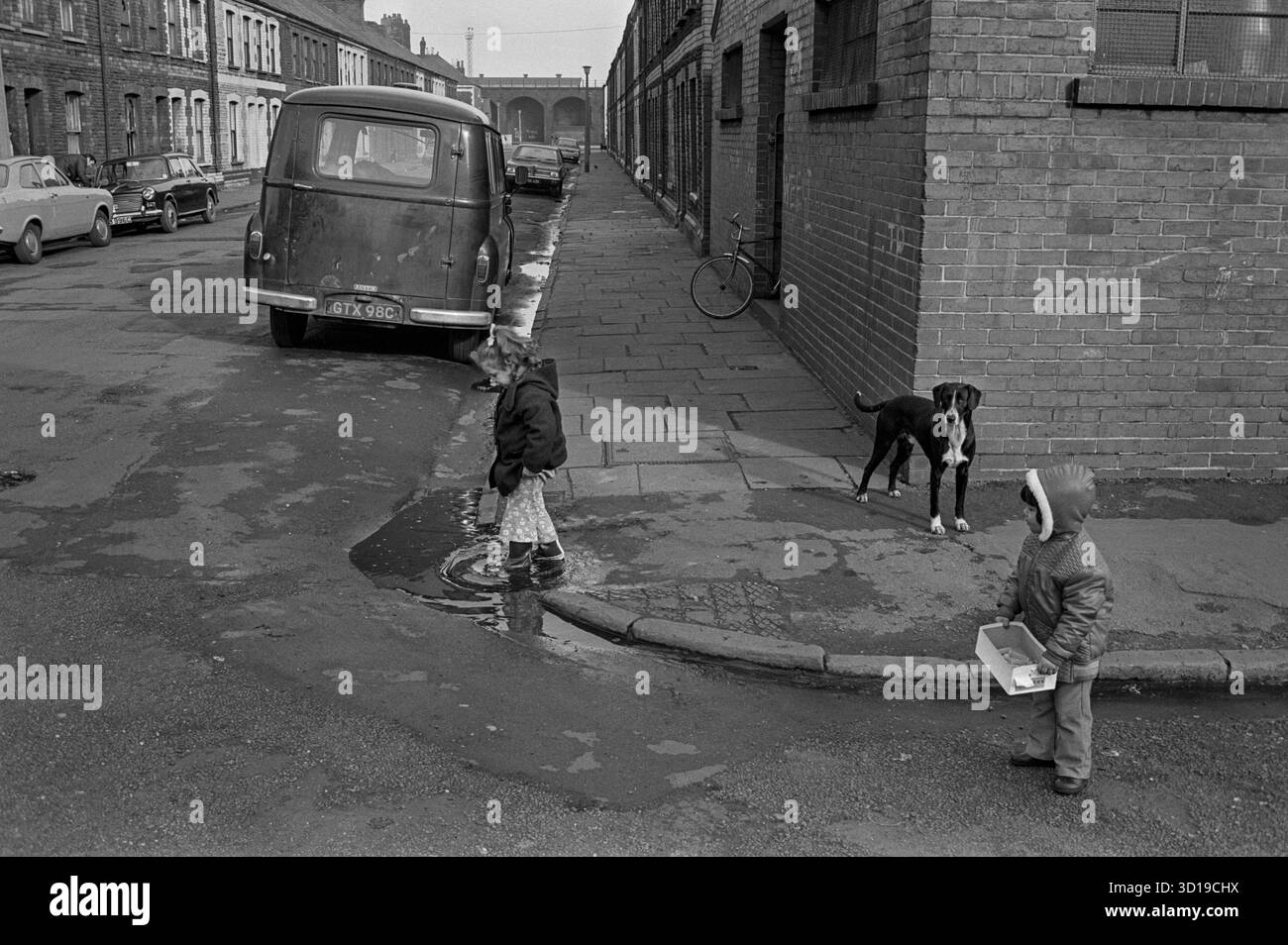 Children playing in a puddle, Pontypridd Street, Splott, Cardiff, 1974 ...