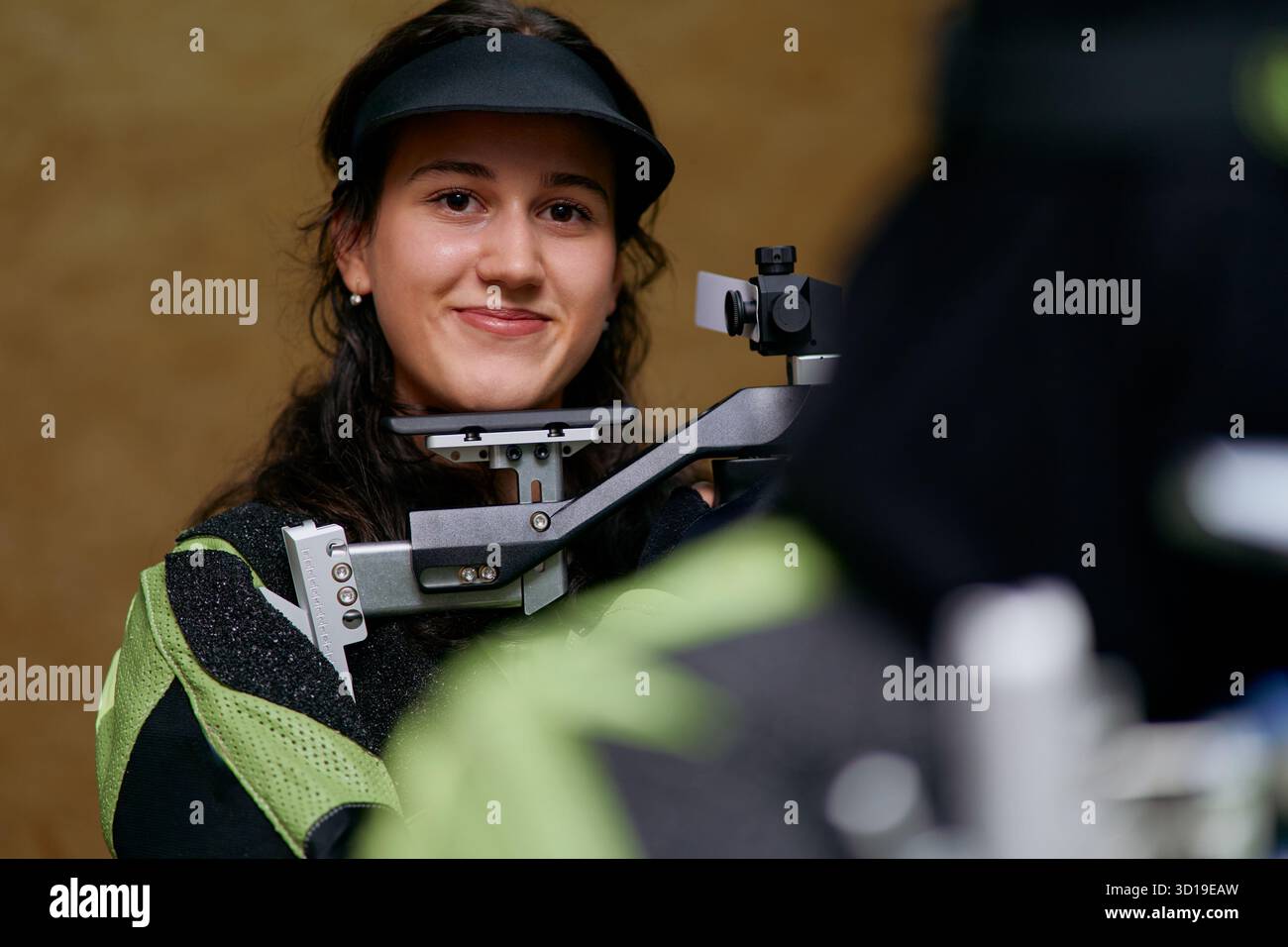 Female rifle shooter aiming, focused on target, competitive sport ...