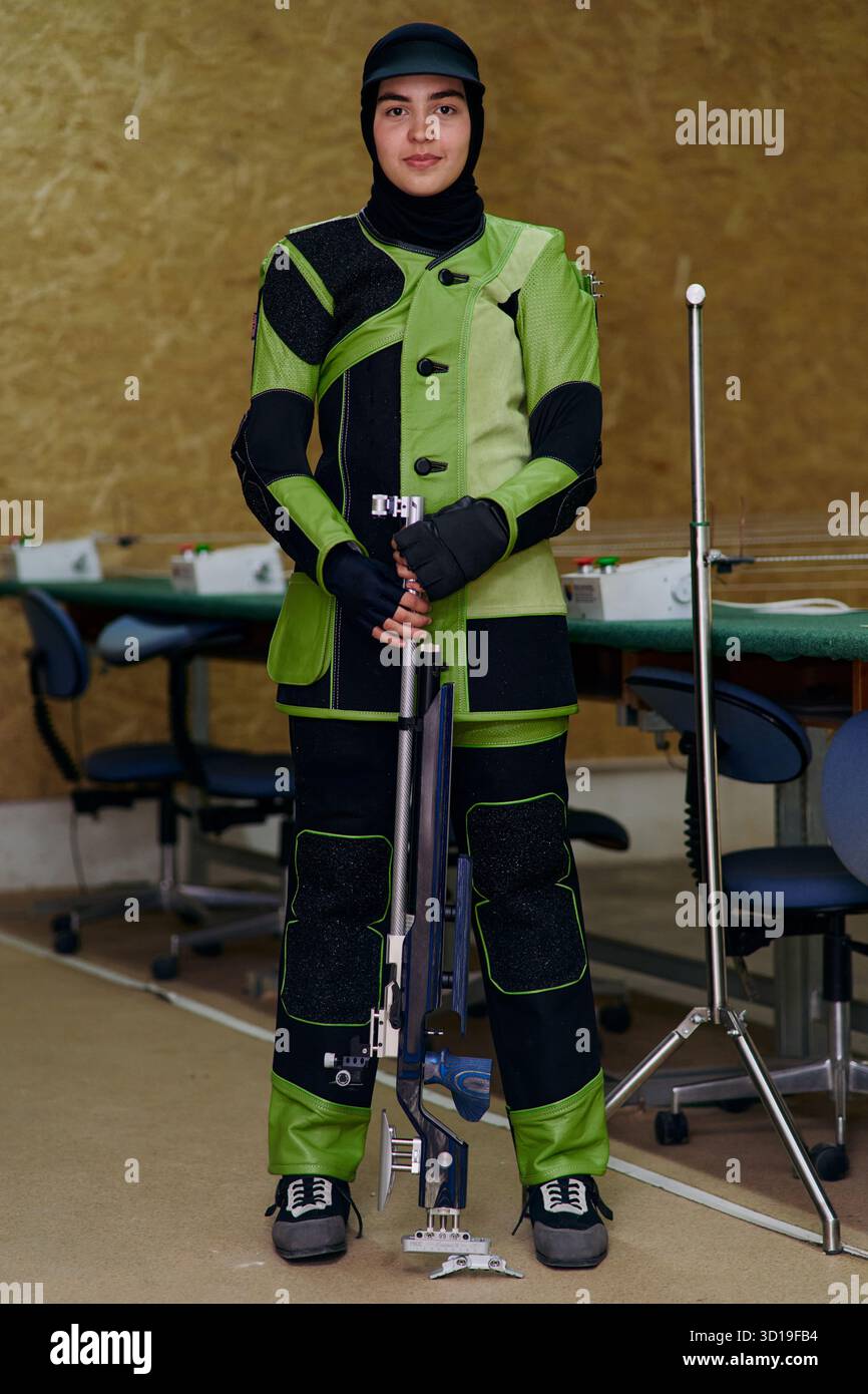 Female rifle shooter in uniform holding a rifle, woman athlete in ...