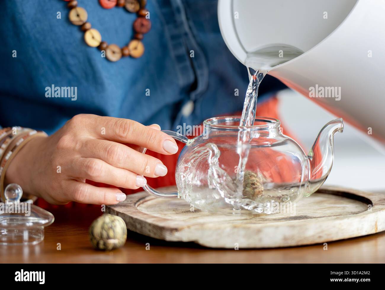 Woman Brewing Tied Green Tea In A Glass Teapot Stock Photo - Alamy
