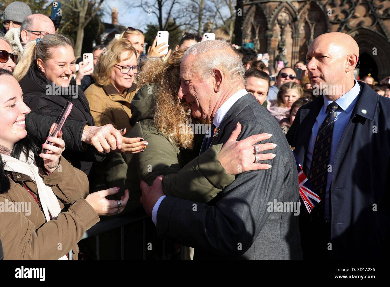 Britain's King Charles III embraces a well wisher, after his visit to Lichfield Cathedral, in ...