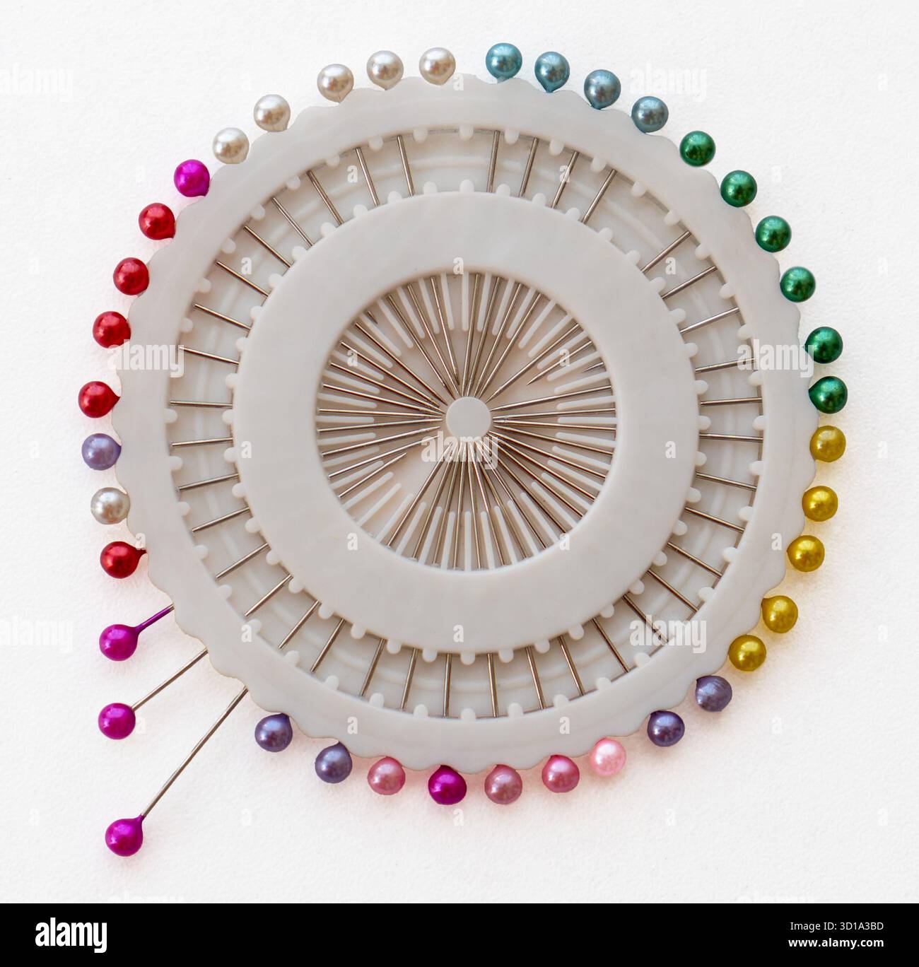 Pins are in a round storage container. Colorful pinheads are kept ...