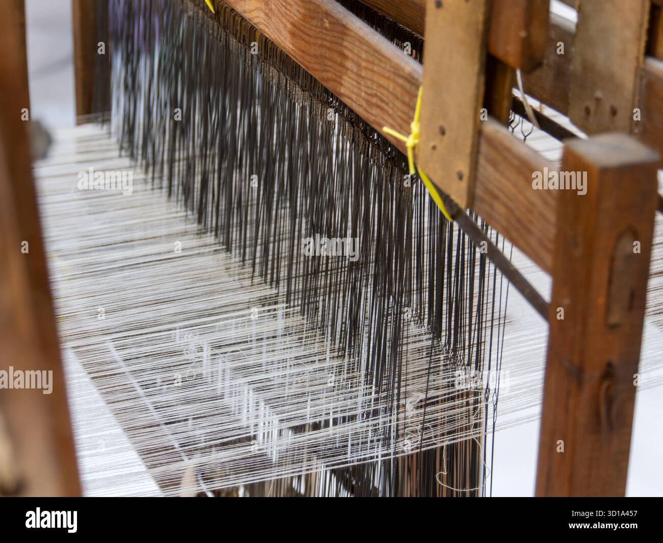 Wooden handloom with spools of thread and a wooden shuttle, traditional ...