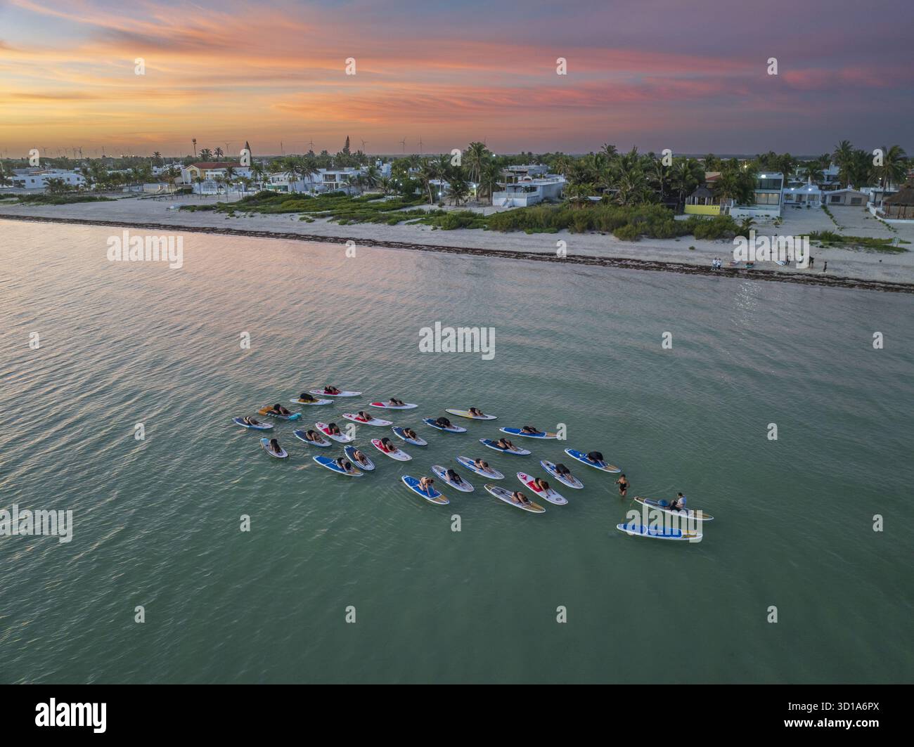 Aerial view of paddleboarders floating on the tranquil turquoise waters ...