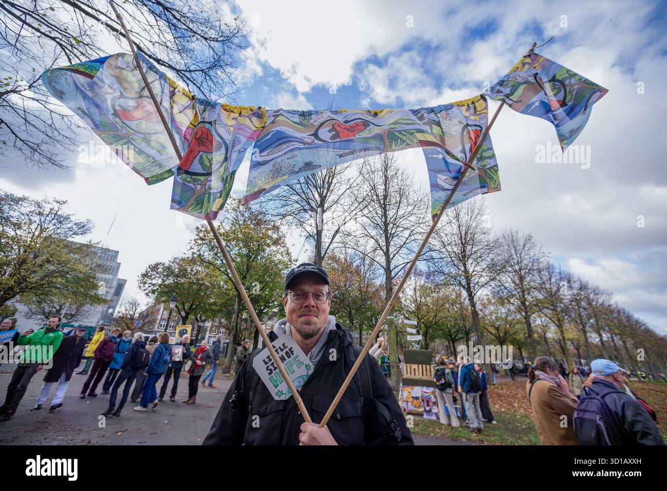 A man holds multi colored flags expressing his opinion during the ...
