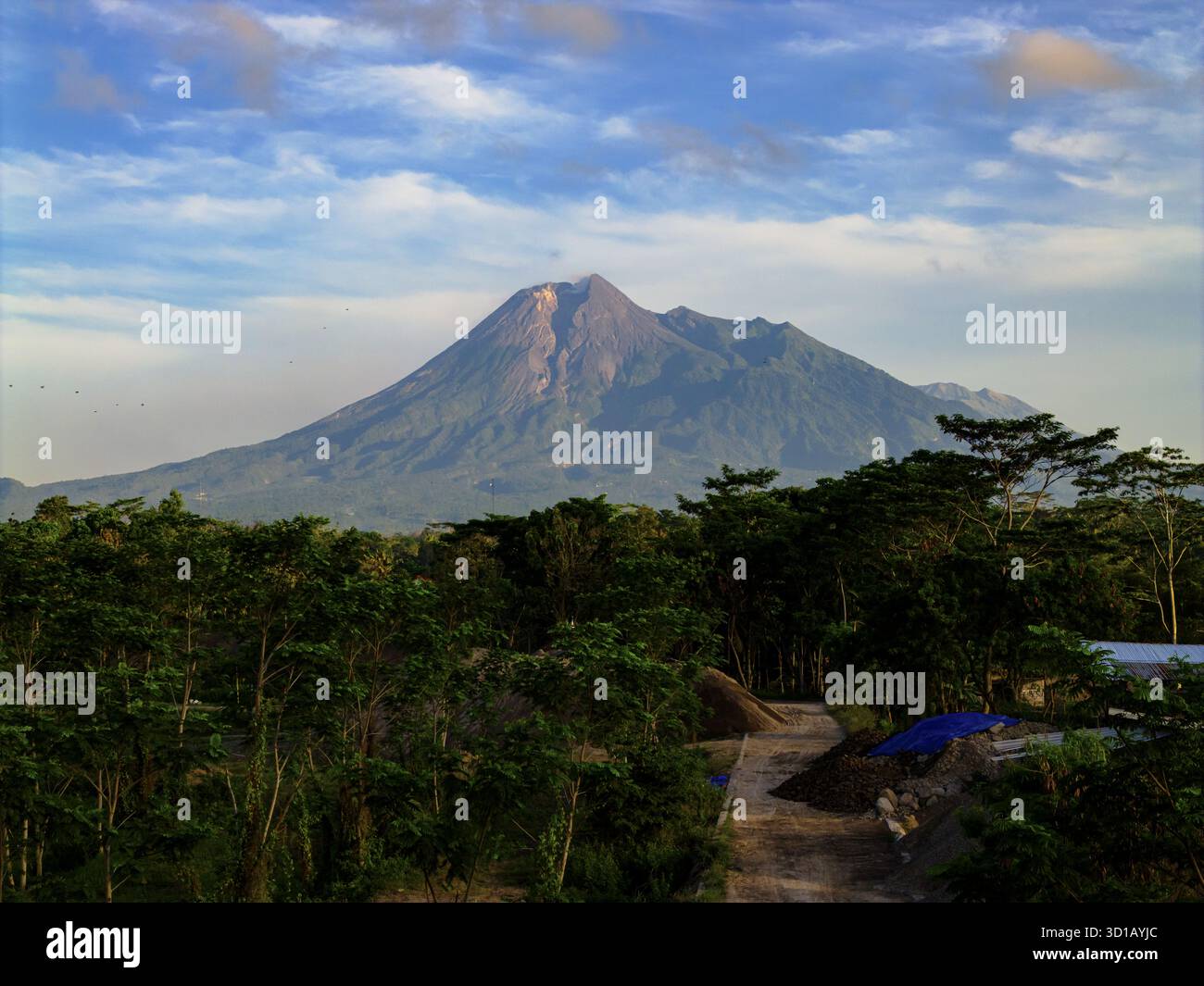 Aerial view of the majestic Mount Merapi rises above the lush green ...