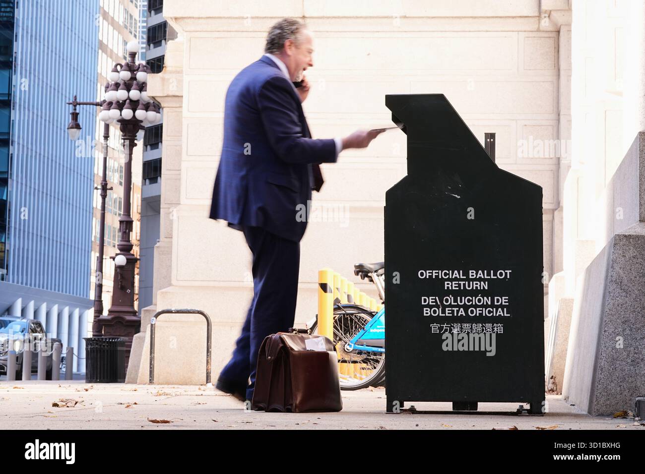A person places an envelope in a ballot return box for mail-in ballots ...