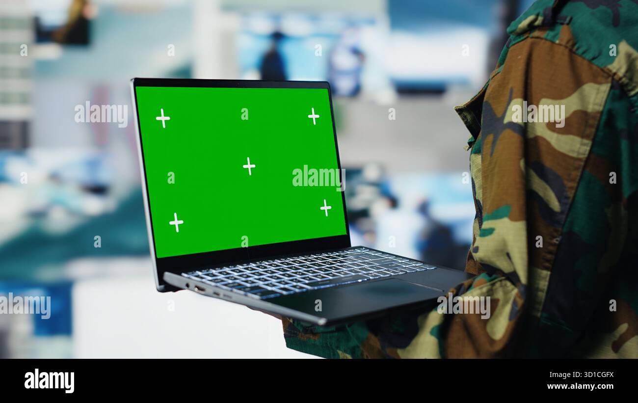 Green screen mockup laptop used by soldier in war room operating CCTV ...