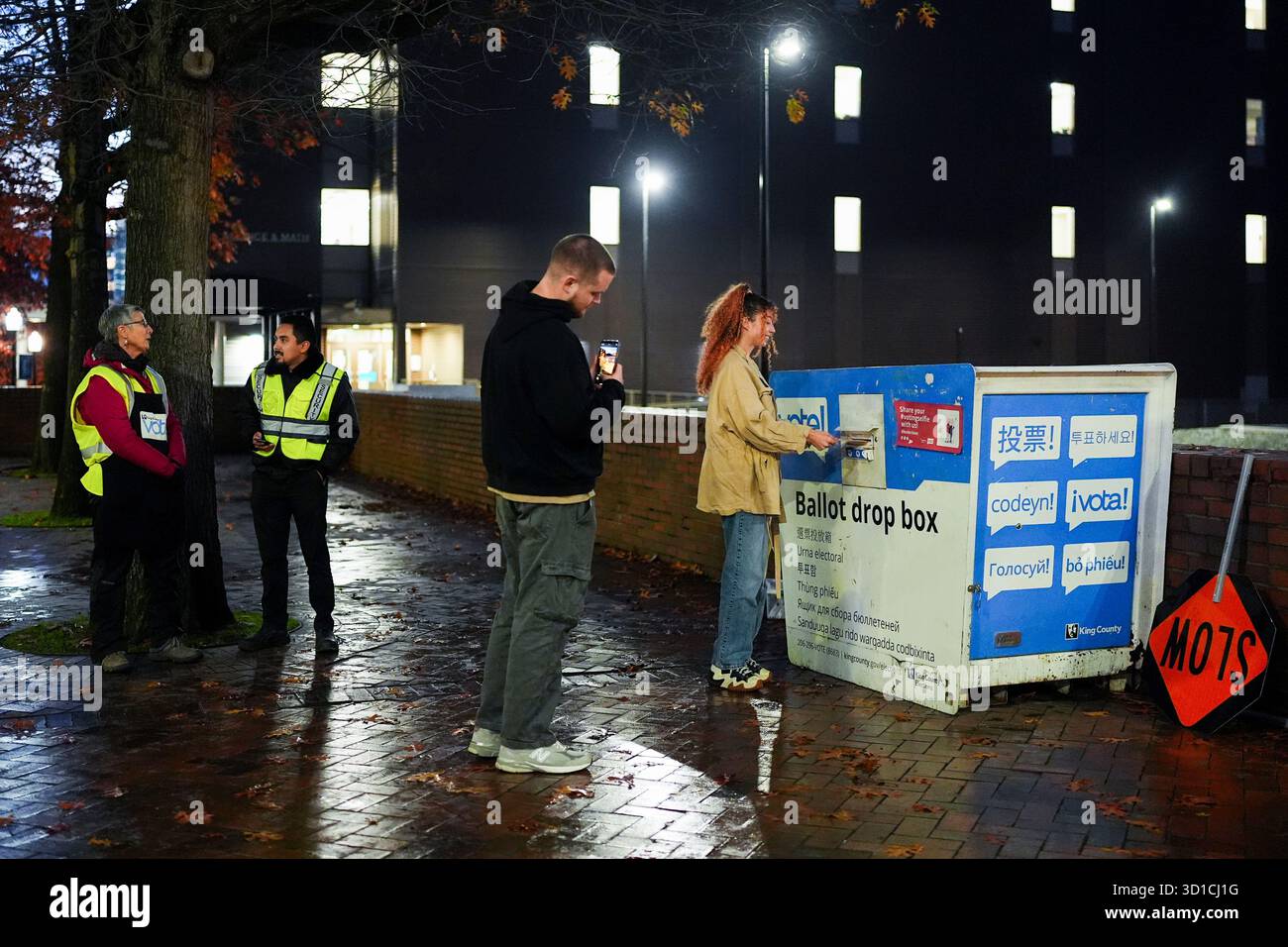 FILE - A voter poses for a photo as they place their ballot in a drop ...