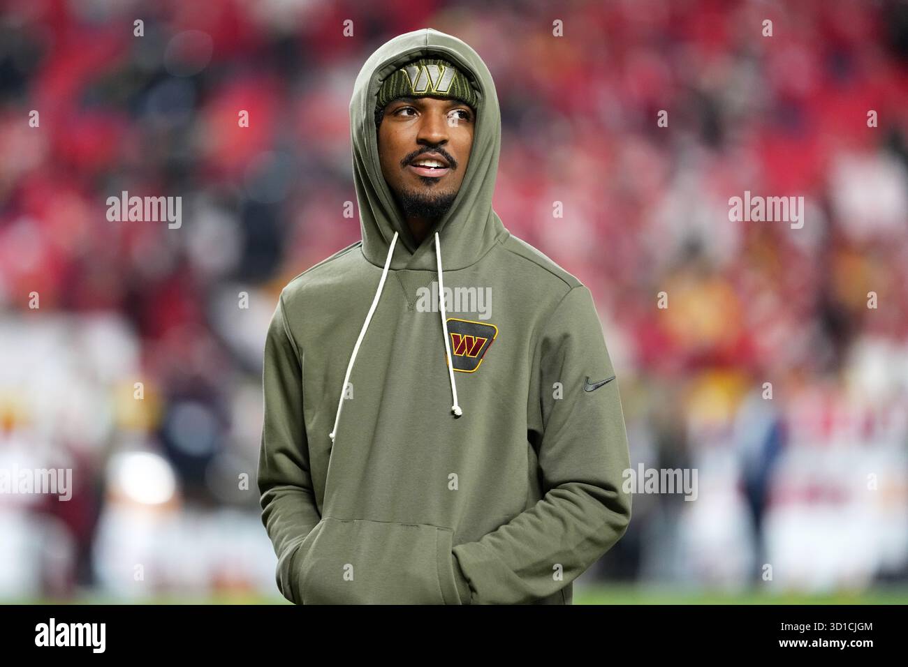 Washington Commanders quarterback Jayden Daniels watches teams warm up ...
