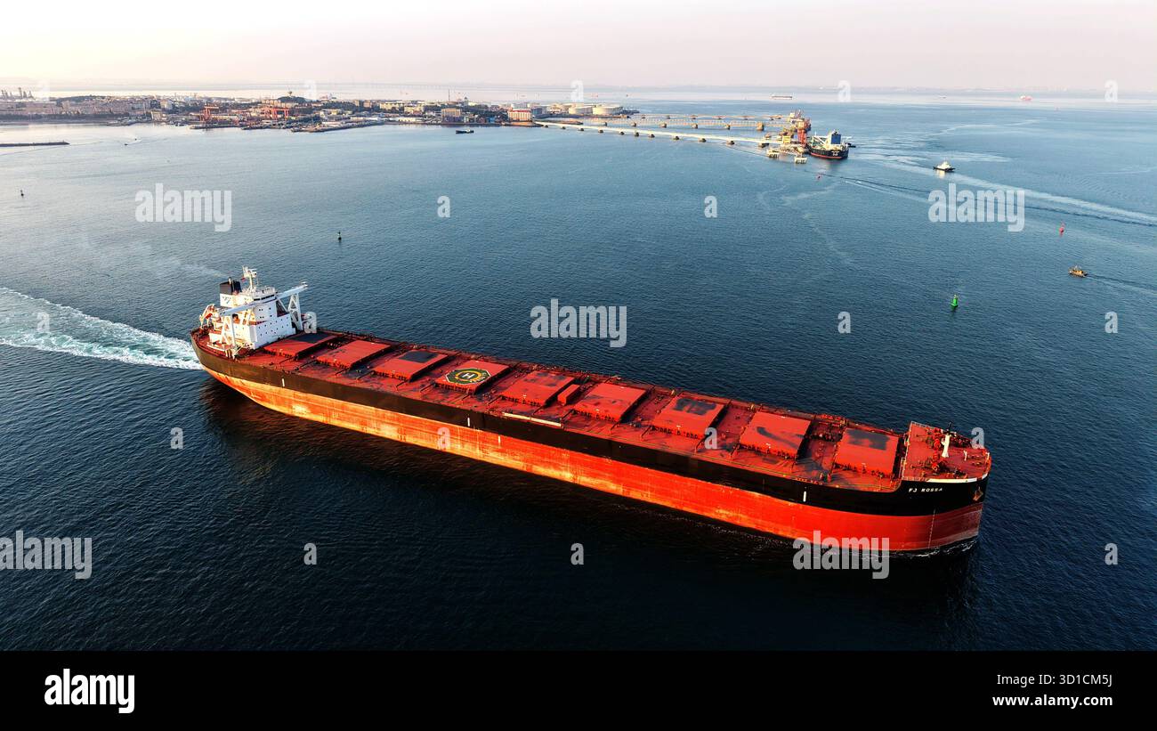 A cargo ship that has unloaded imported iron ore departs from Qingdao ...