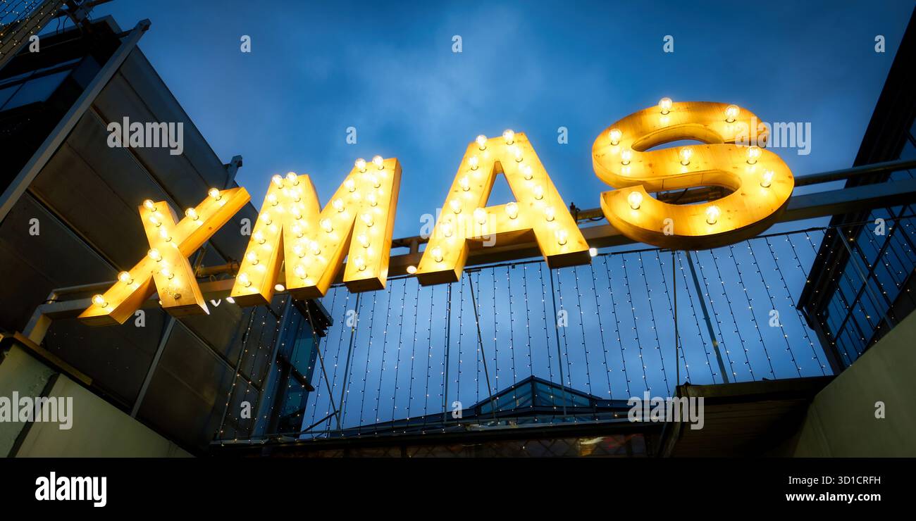 Giant, illuminated "XMAS" sign with marquee lights against a dramatic ...