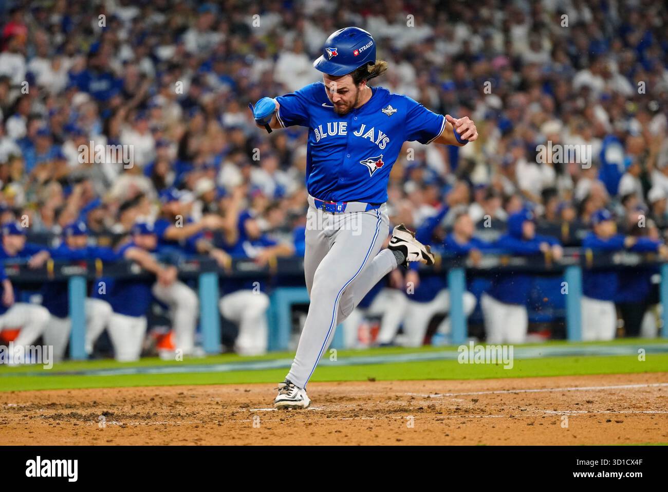 Toronto Blue Jays' Addison Barger (47) loses his helmet as he scores on ...