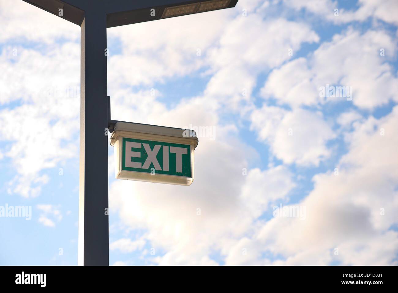 Bright exit sign against a blue sky with clouds Stock Photo - Alamy