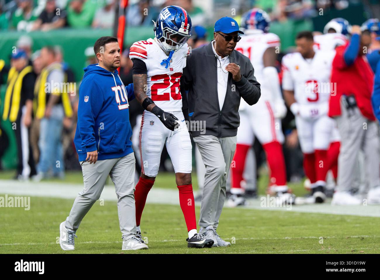 New York Giants corner back Cor'Dale Flott, center, helped off the ...