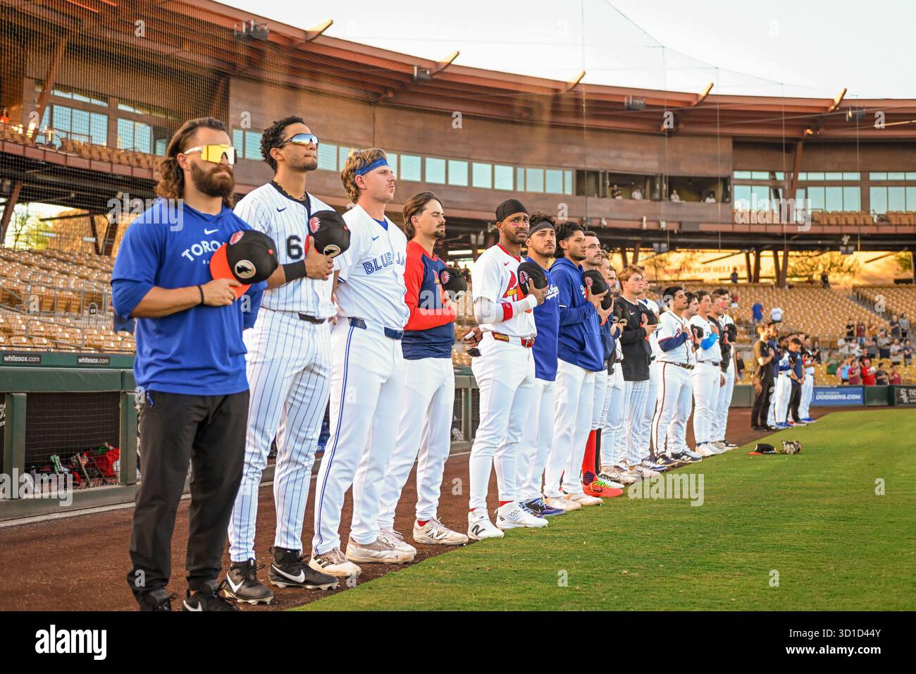 Glendale Desert Dogs stand for the national anthem in the first inning ...
