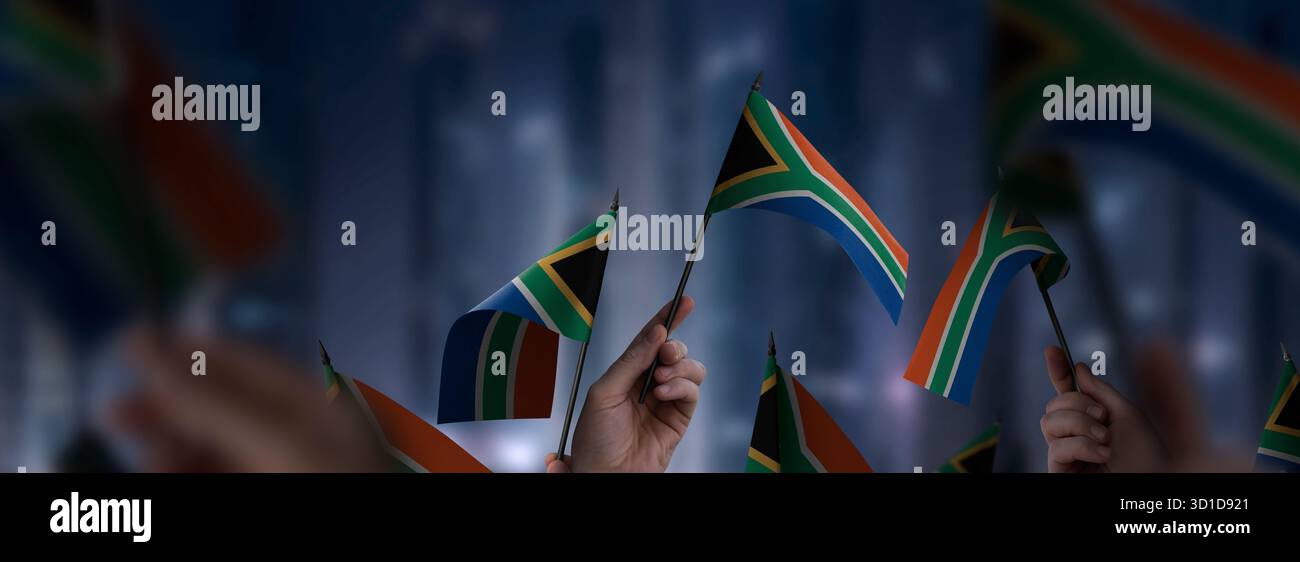 South Africa flags in their hands on a blurred urban background Stock ...
