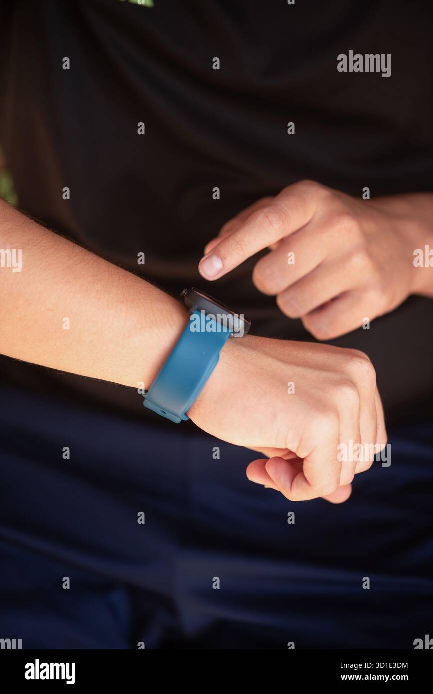 Person using smartwatch on wrist while seated in outdoor setting Stock ...