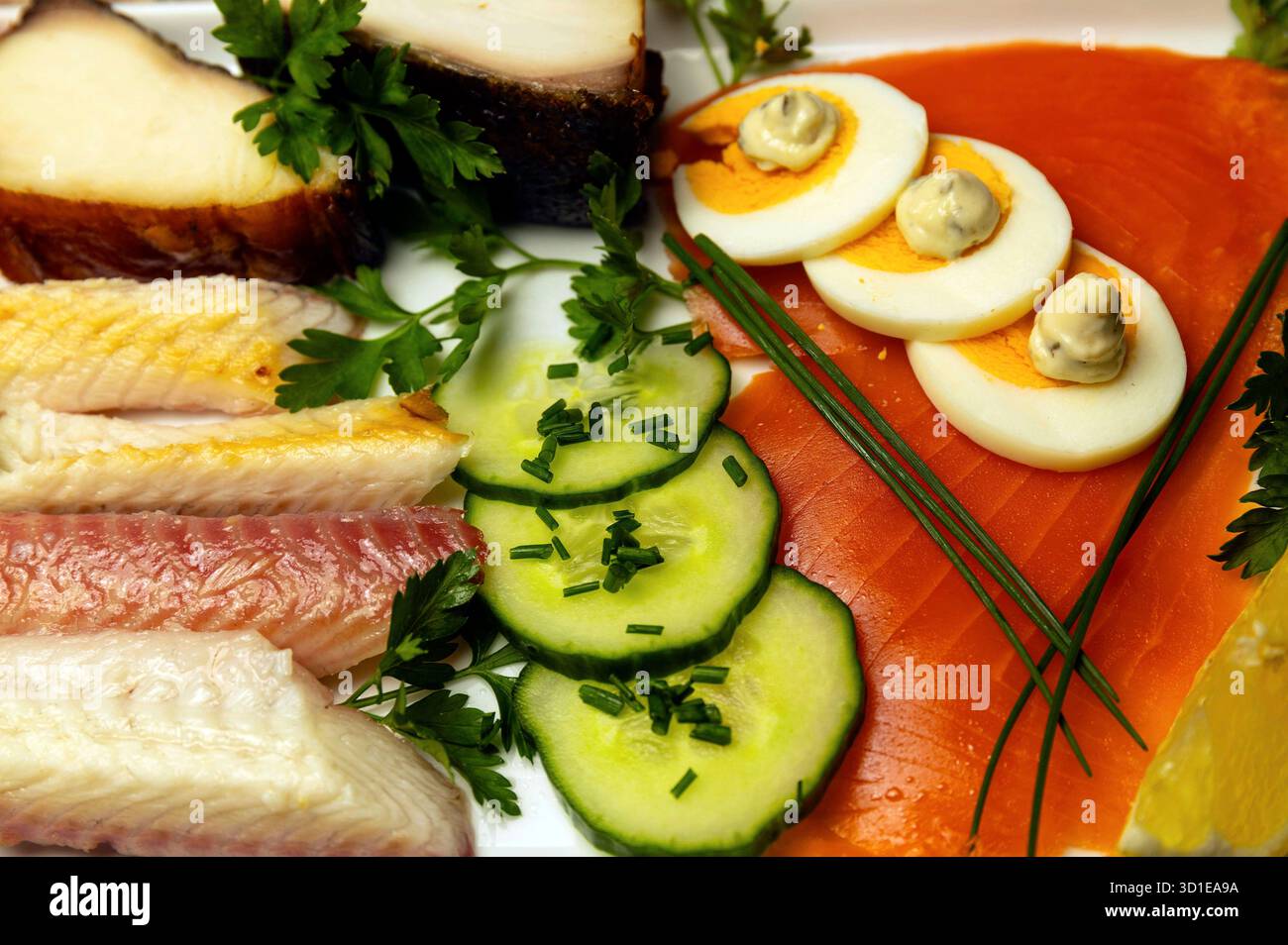 Kalte Fischplatte mit Aal, Butterfisch, Lachs, Gurken, Petersilie ...