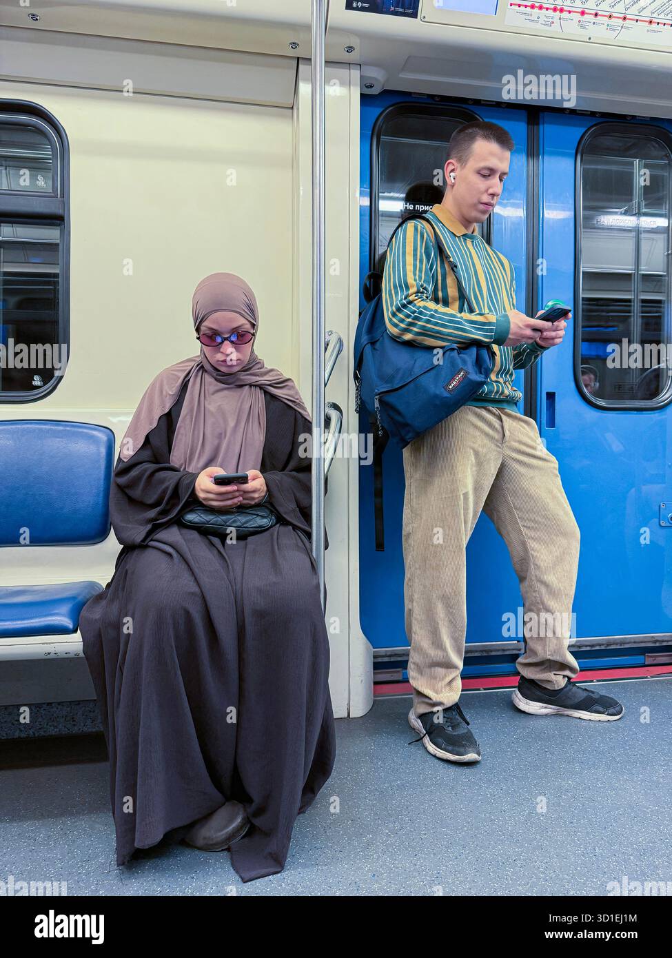 Moscow, Russia, 12 August 2025, Two passengers focused on their mobile ...