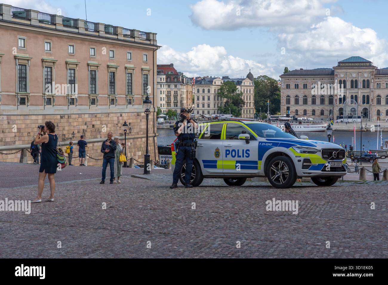 Stockholm, Sweden - 08.05.2025: Two policemen with guns and police car ...