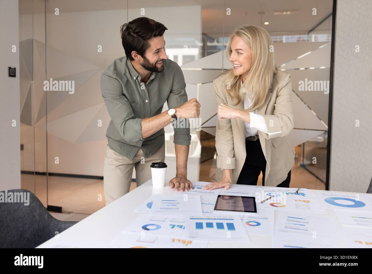 Couple of happy young analysts giving fist bump hand gesture Stock ...