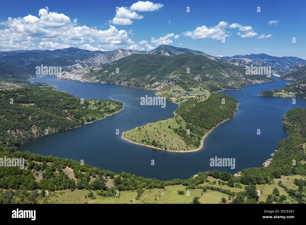 Scenic view of a river winding through green fields and rugged ...