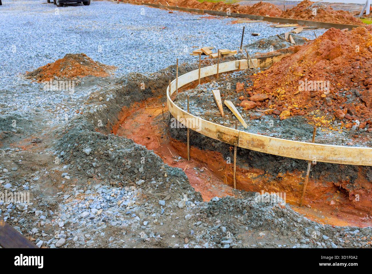 Workers prepare gravel base set wooden forms for foundation at ...