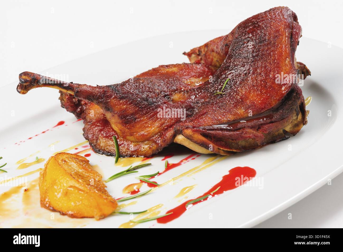 Roast half of duck with caramelized lemon on white plate Stock Photo ...