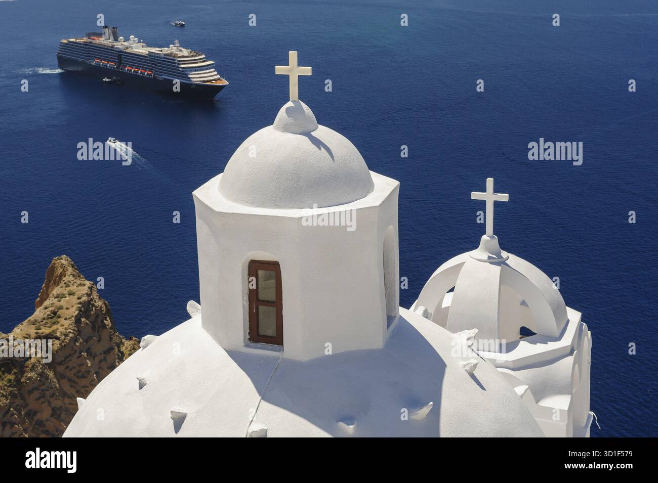 White orthodox church bell tower and sea with ships at background. Fira ...