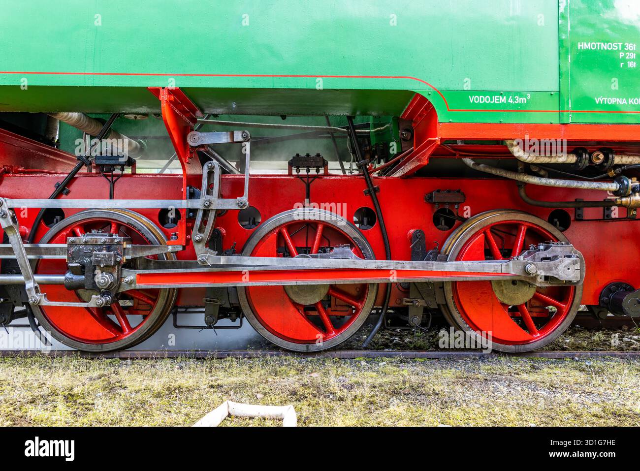 Detail of the bright red driving wheels and rods of a vintage green ...