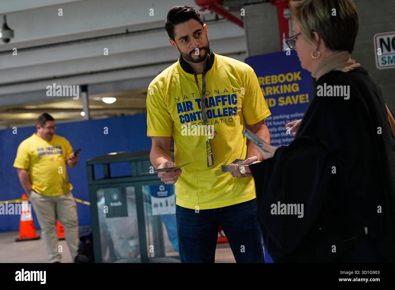 Jose Rodriguez, an air traffic controller, hands out pamphlets urging ...