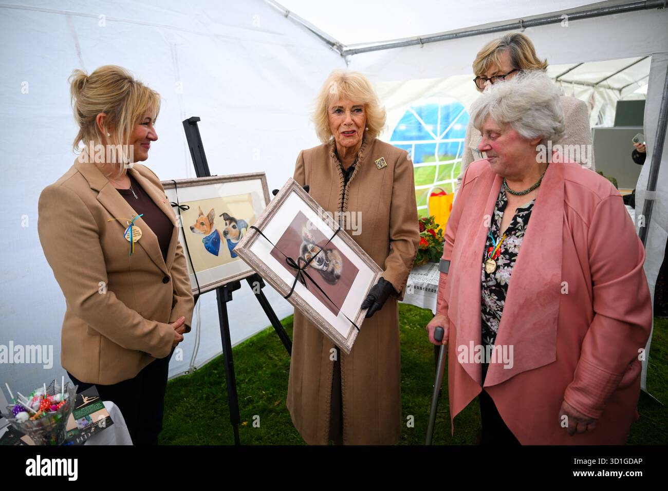 Queen Camilla receives a gift of artwork depicting her dog Moley during ...