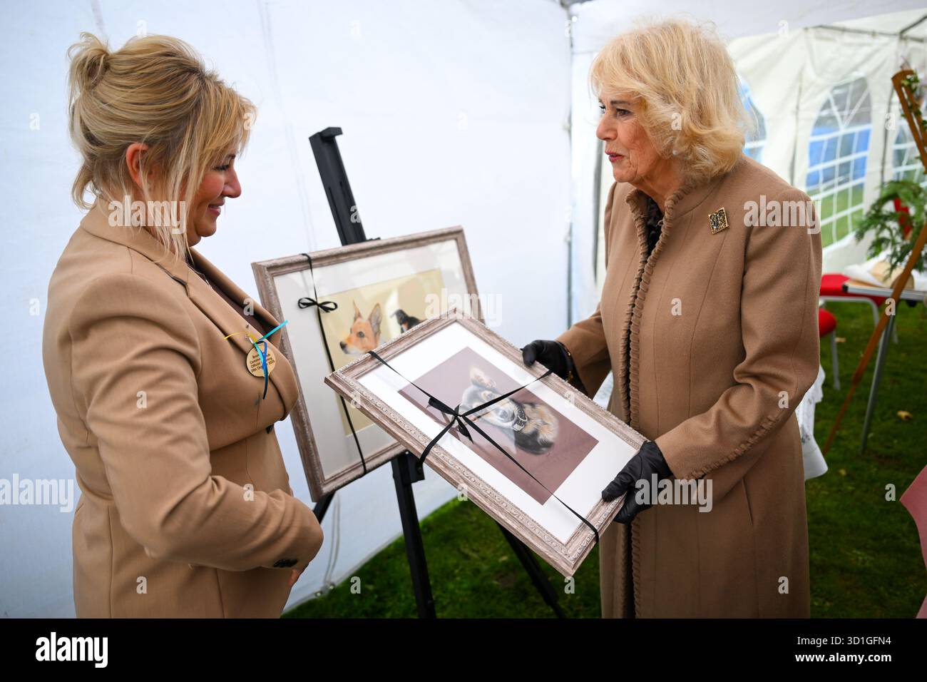 Queen Camilla receives a gift of artwork depicting her dog Moley during ...