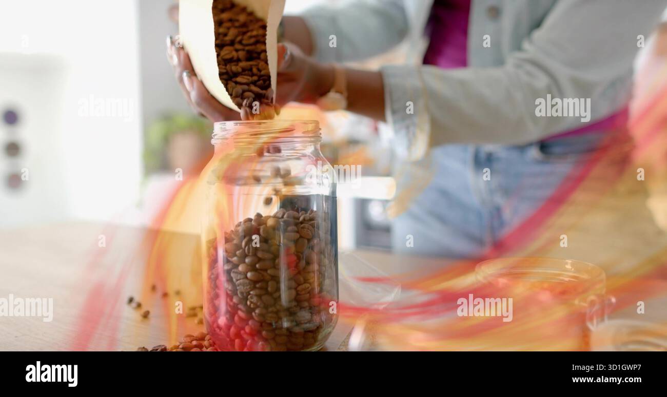 Woman in denim jacket pouring coffee beans from paper bag into glass ...