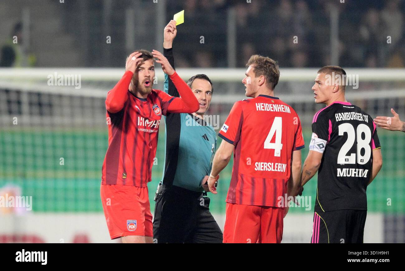 from left: Julian Niehues (Heidenheim, yellow card), referee Benjamin ...