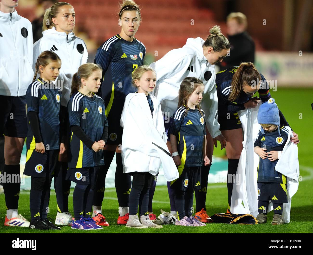 A Scotland player wraps a jacket around a mascot ahead of the ...