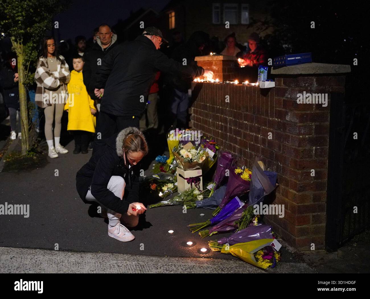 People lay flowers and light candles near Midhurst Gardens in Uxbridge ...