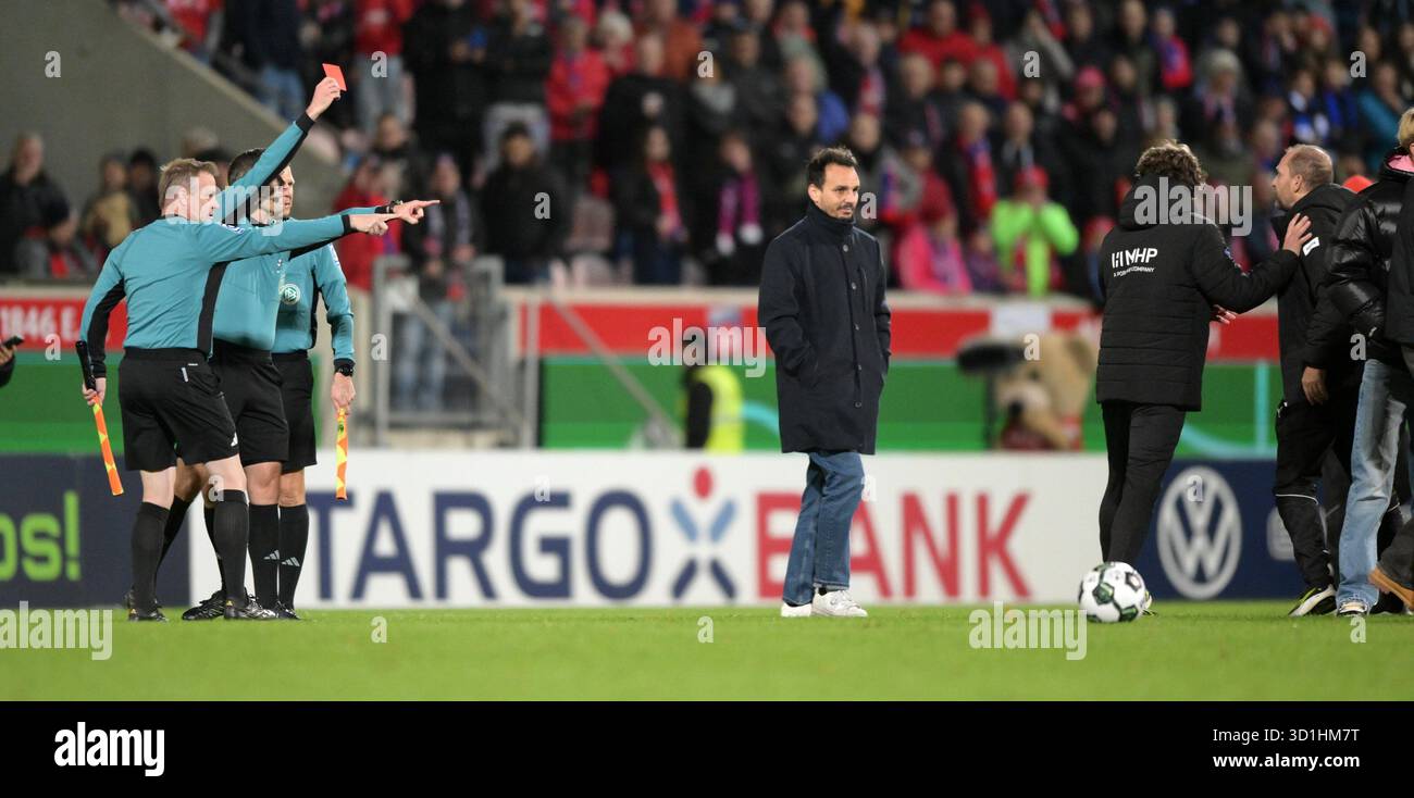 Referee Benjamin Brand shows a team staff member from Heidenheim the ...